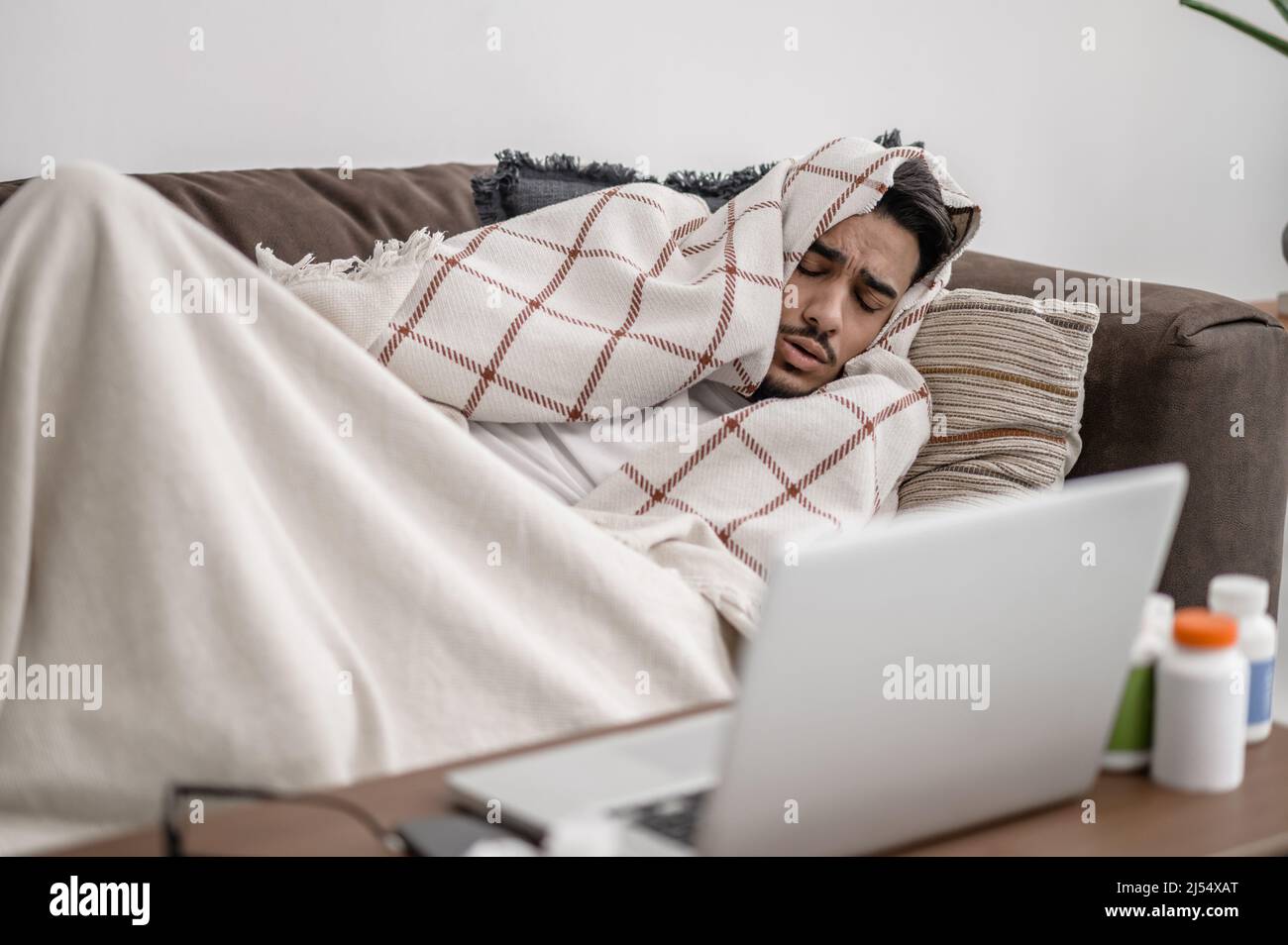 A sick man feeling bad and lying in bed Stock Photo - Alamy