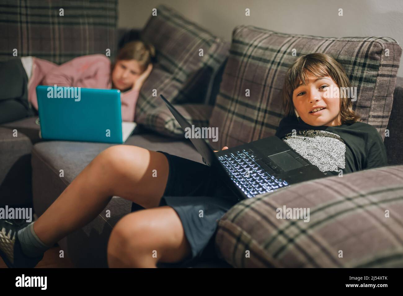 Social alienation of teenagers. Two children using laptop at home ...