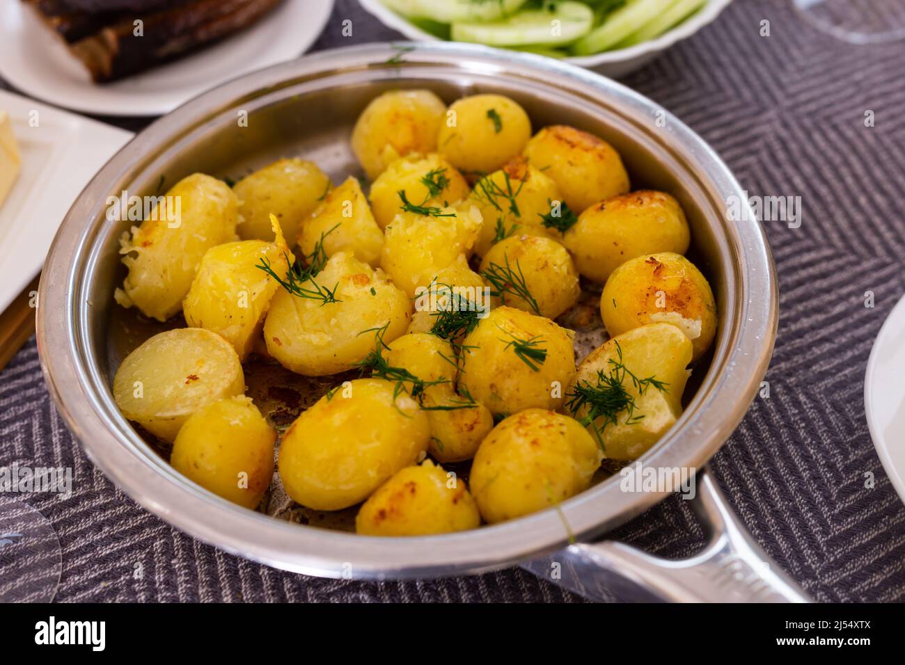 toasted young potatoes with dill in metal skillet Stock Photo - Alamy