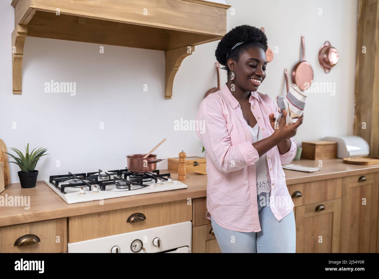 Contented african woman in pink clothes drying hands Stock Photo - Alamy