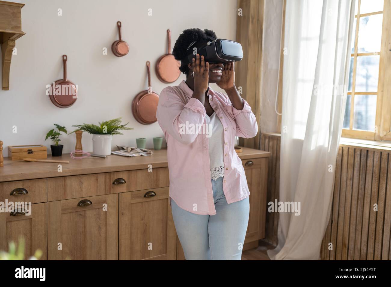 Contented african woman in pink clothes in VR galsses Stock Photo - Alamy