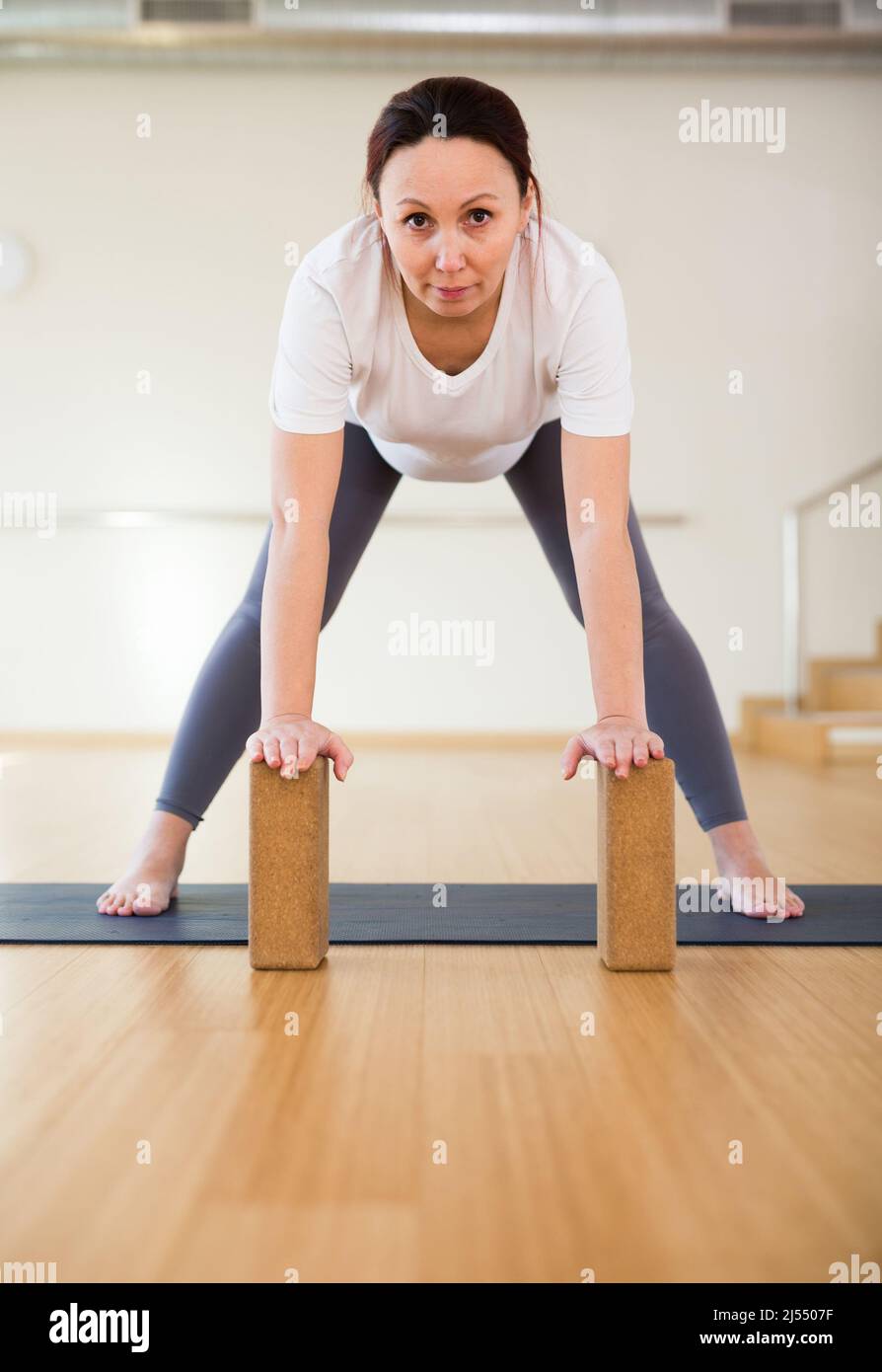 Pregnant woman is engaged in yoga. Standing Half Forward Bend or Ardha ...