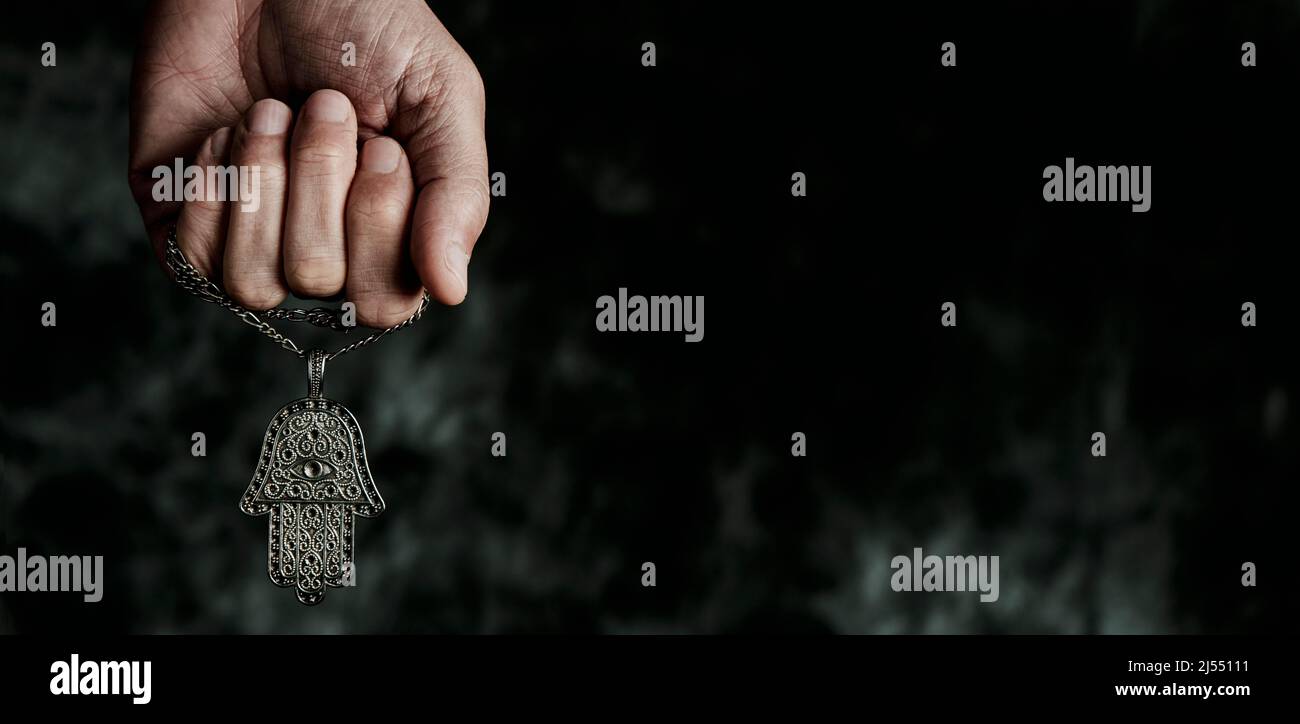 a man holds an old hamsa amulet, also known of the hand of fatima or ...