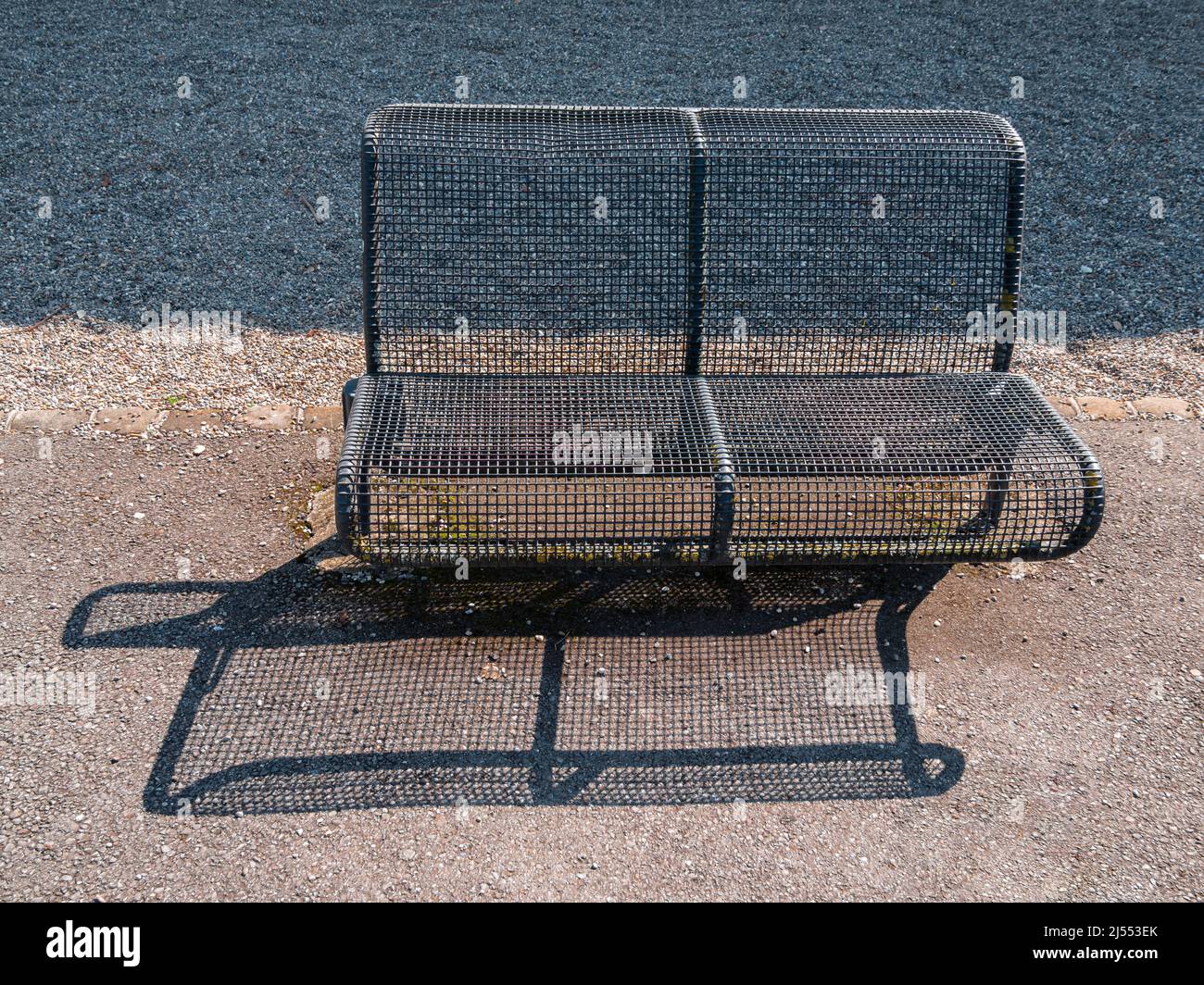 A metal bench in the park and its shadow in the midday sun Stock Photo ...