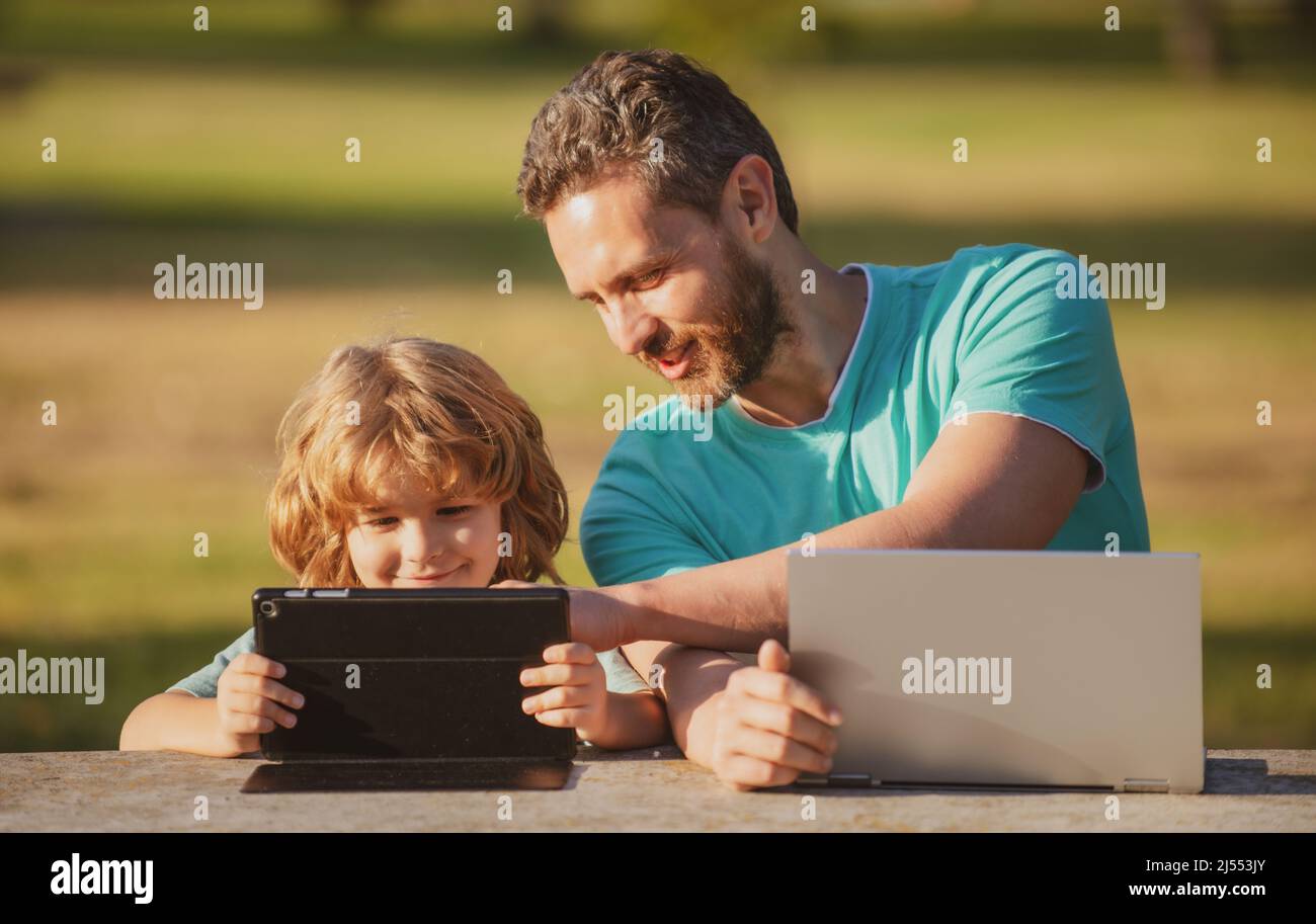 Happy father using laptop relax with schooler son holding laptop have ...