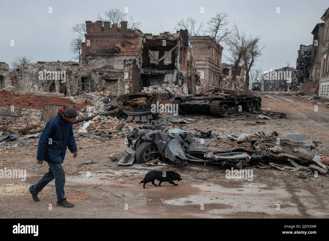 Mariupol, Ukraine. 12th Apr, 2022. A man walks by a destroyed T72 tank ...