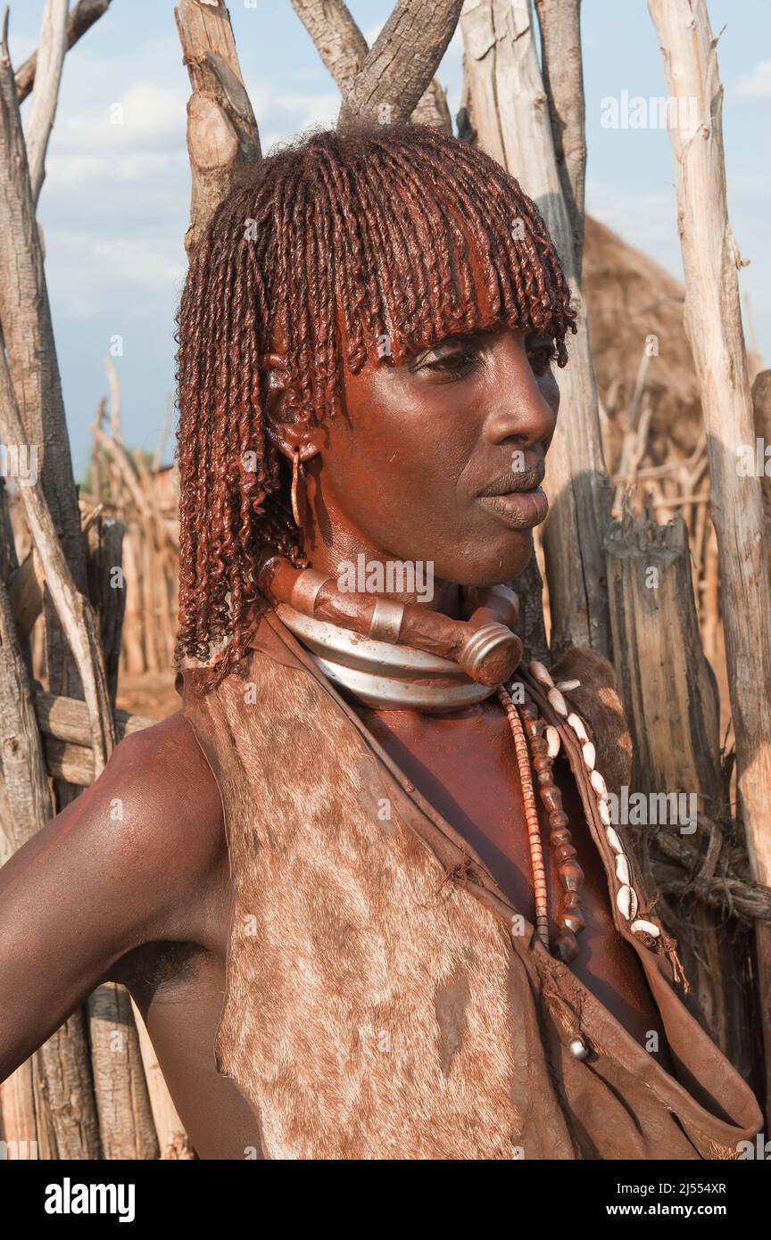Young Hamar woman with red clay in her hair and wearing a goat dress ...