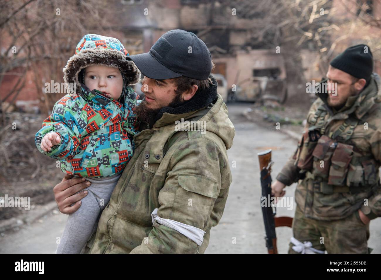 Chechen fighter poses with a baby at a humanitarian aid distribution ...