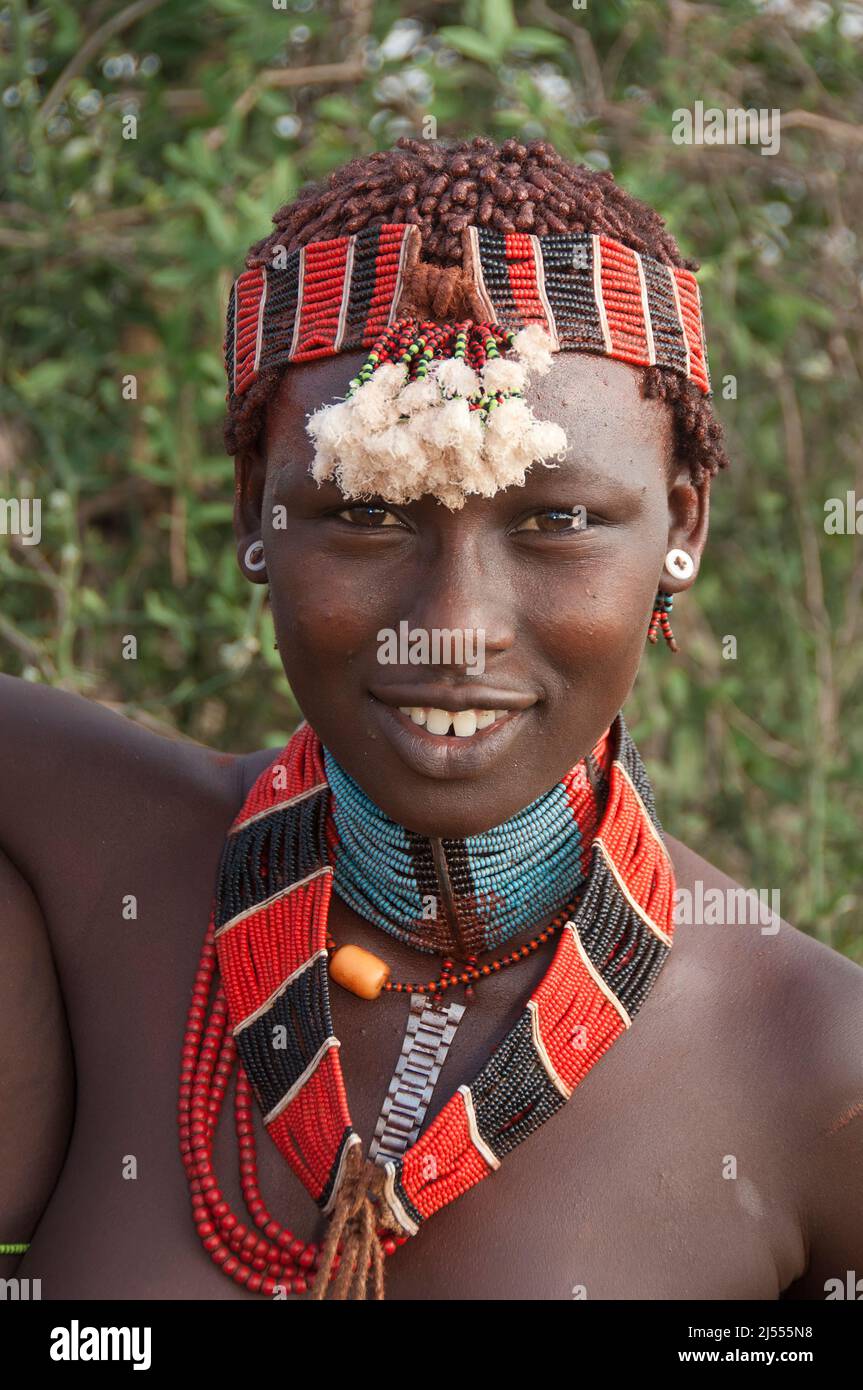 Portrait of a young Hamar woman with colorful necklaces and head ...