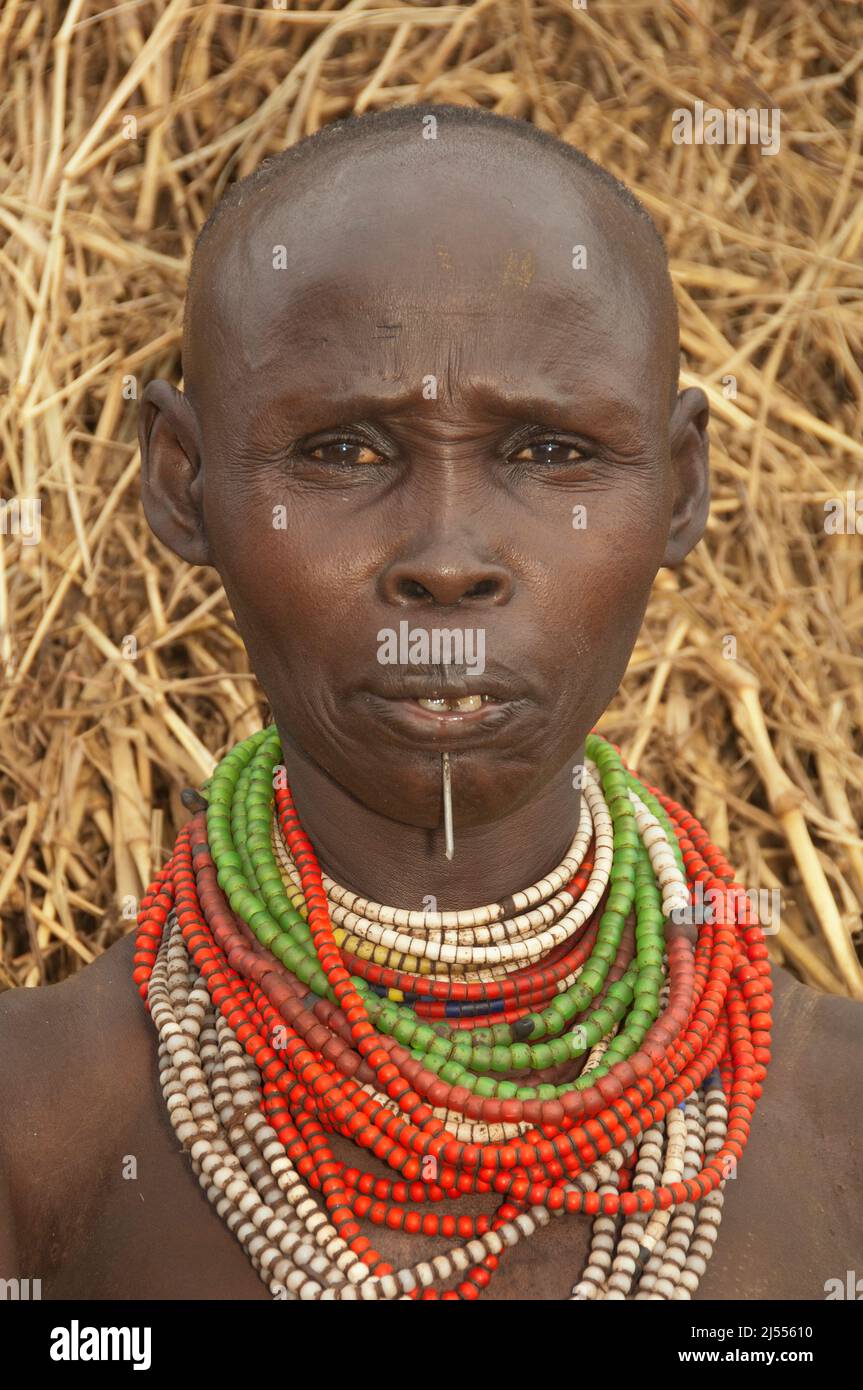 Karo woman with lots of colorful necklaces and Cowry shells, lip ...