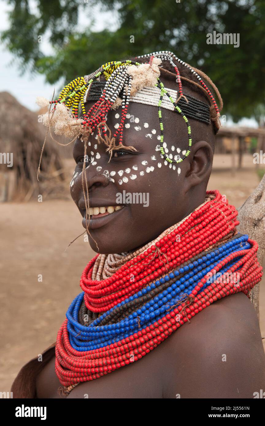 Young Karo woman with lots of colorful necklaces, facial paintings and ...
