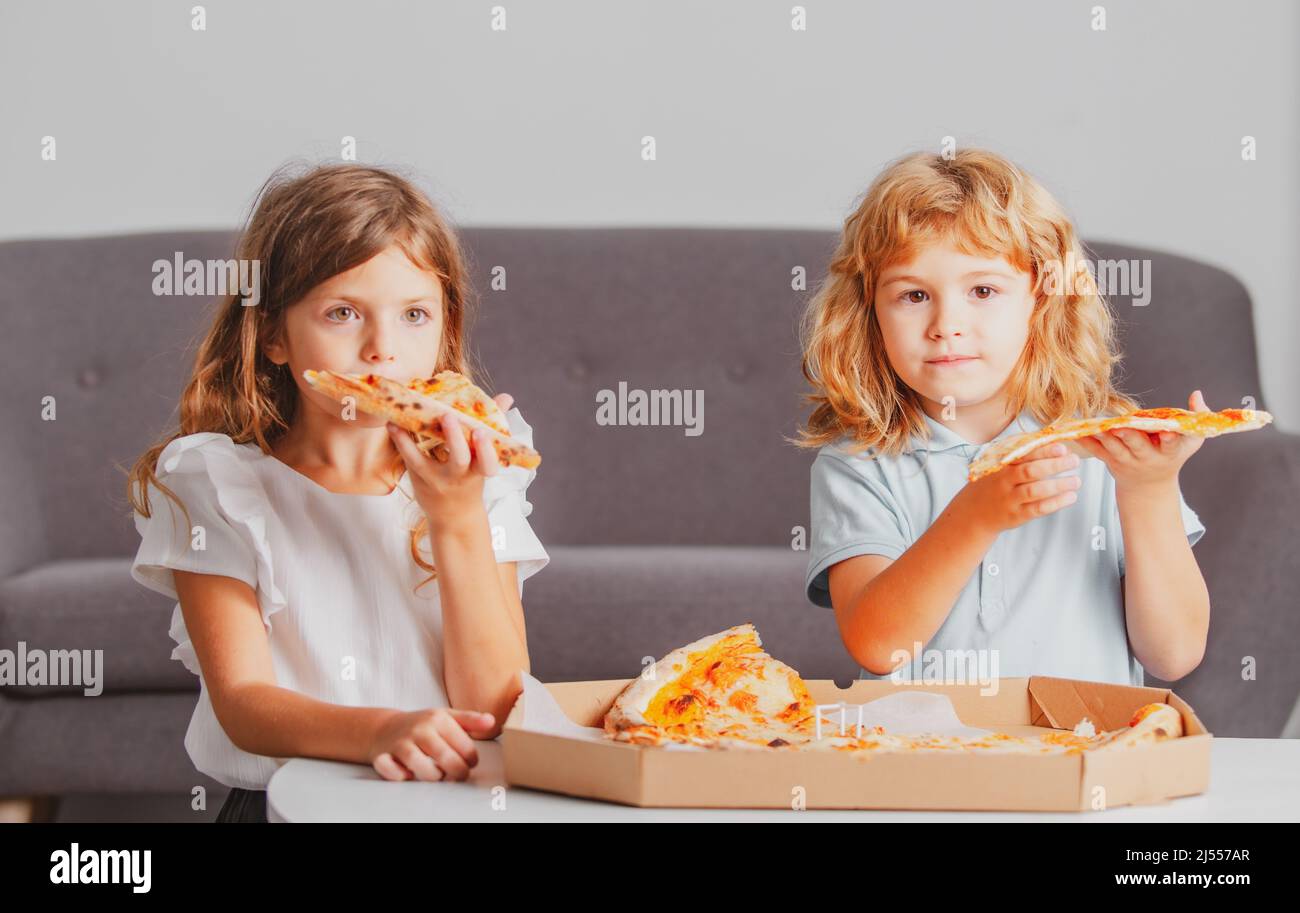 Happy daughter and son eating pizza. Children kids enjoy and having fun ...