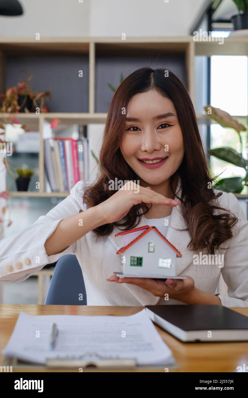 A woman holding and checking house model .Real Estate House Appraisal ...