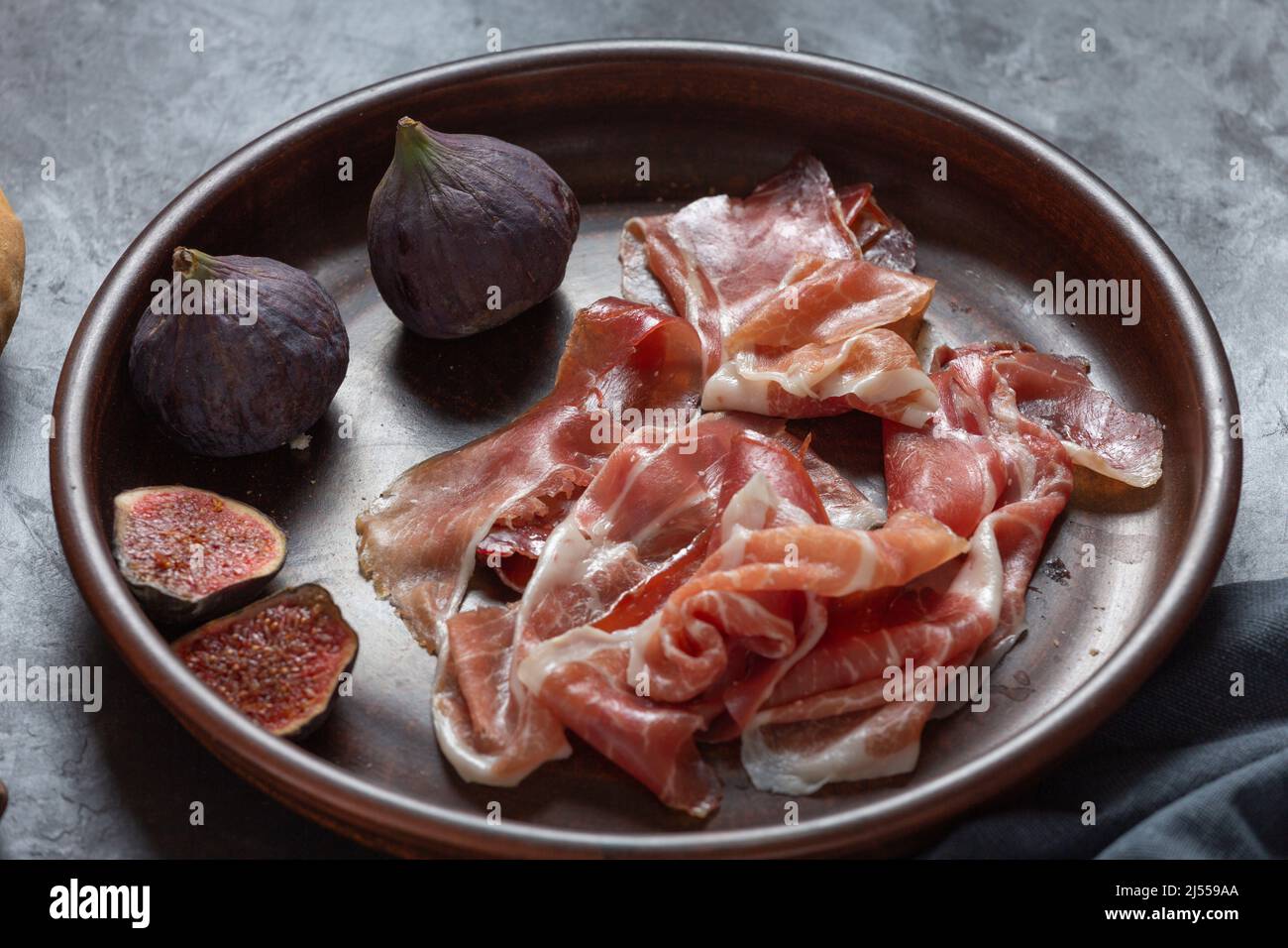 Jamon with figs and a baguette with cream cheese on the dining table ...