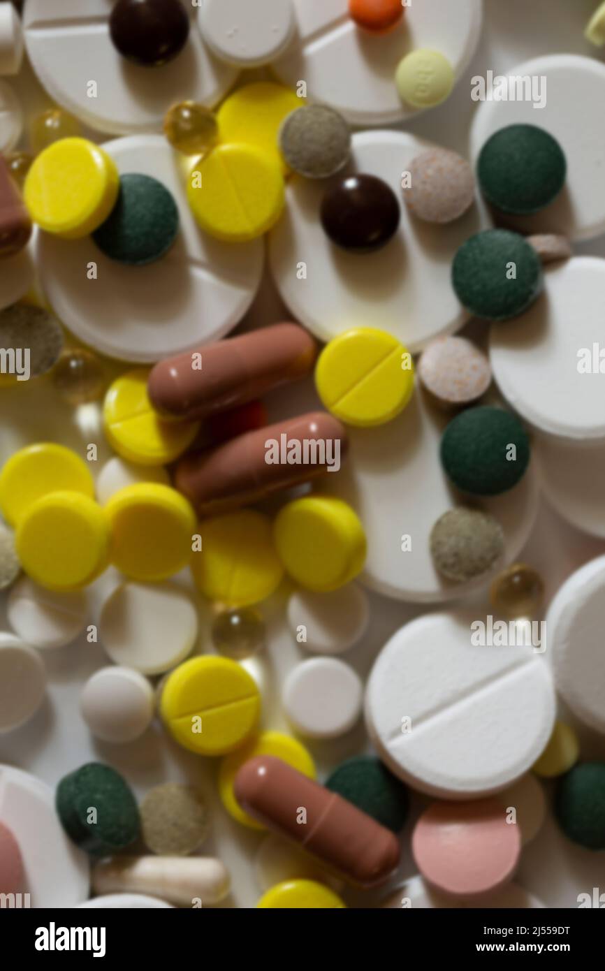Blurred background of pills of different colors and sizes, top view ...