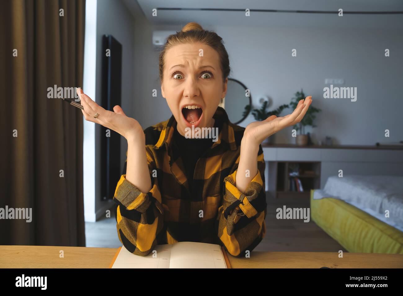 shocked girl at the desk, writing in the notebook Stock Photo - Alamy