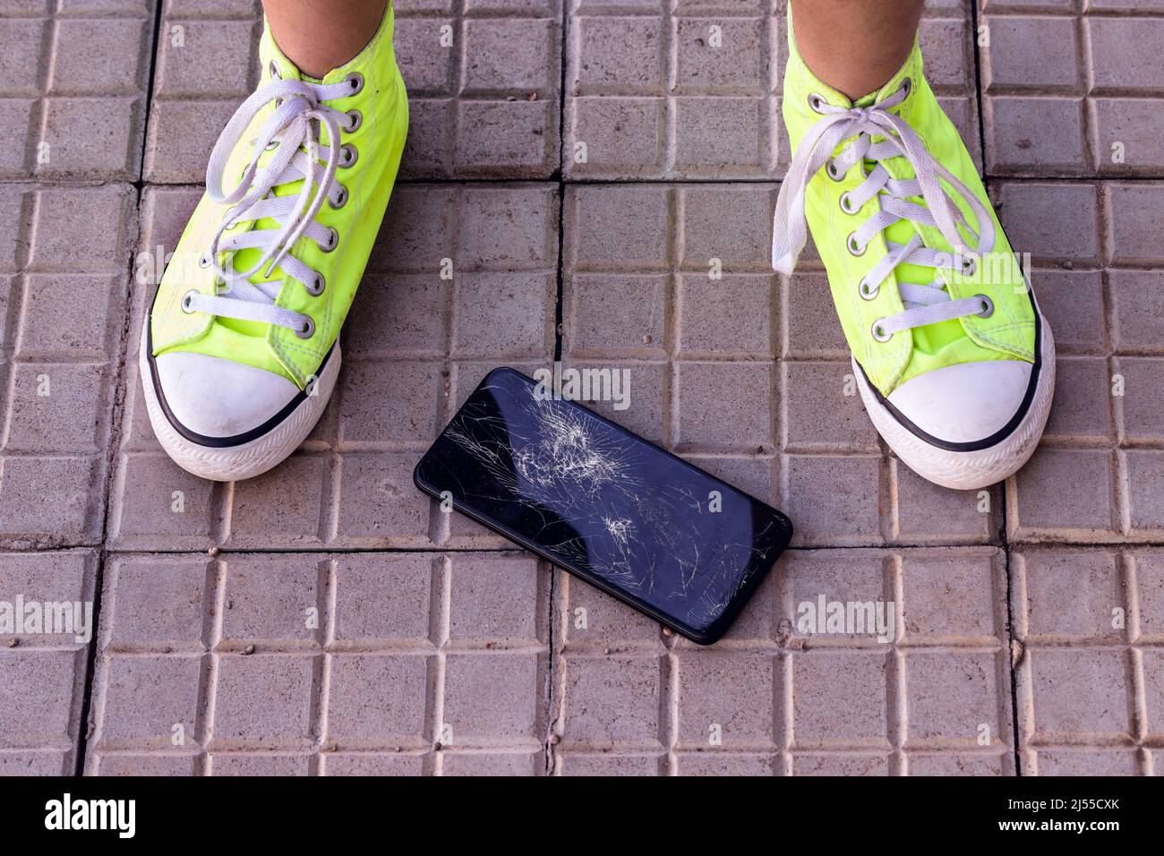 smartphone device dropped on floor with broken screen, top view ...