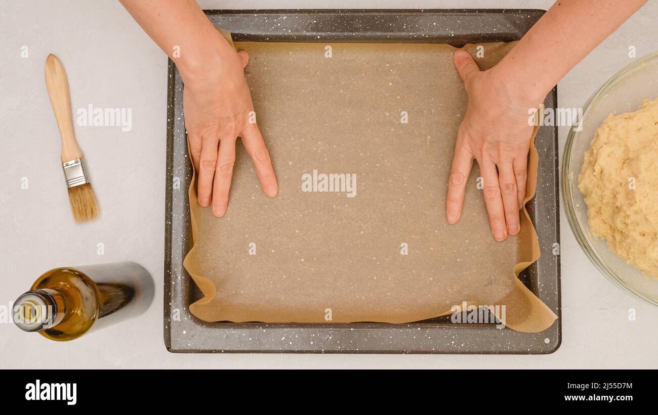 Placing parchment paper onto baking pan. Step by step homemade pizza ...