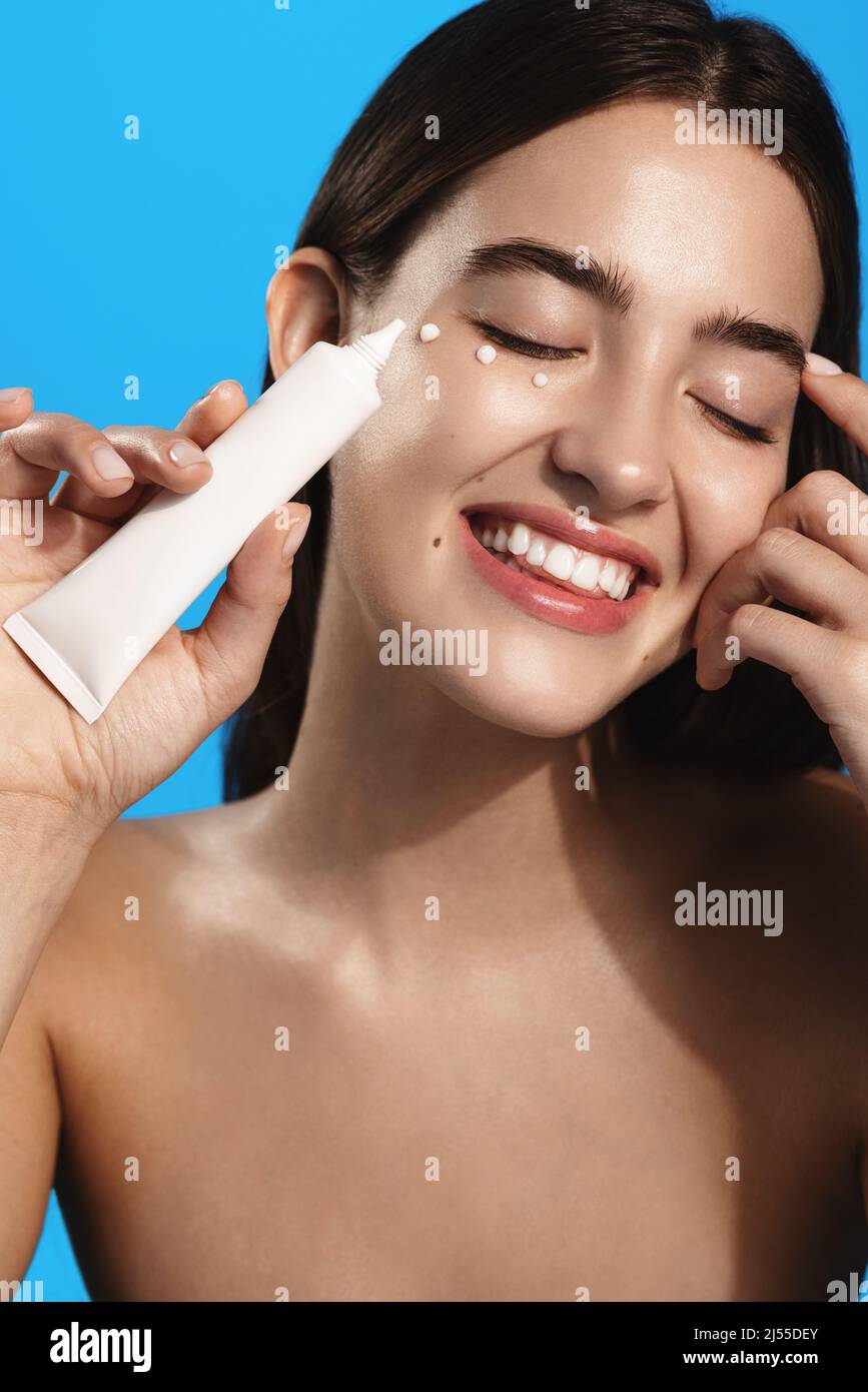 Portrait of happy young woman smiles, shows skin care routine facial ...