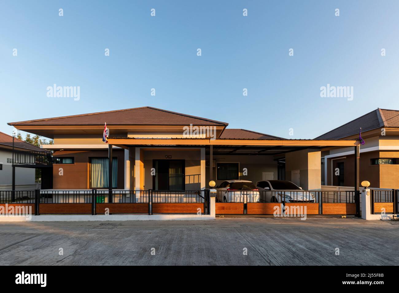 Outside view of the house with green fields against clear blue sky ...