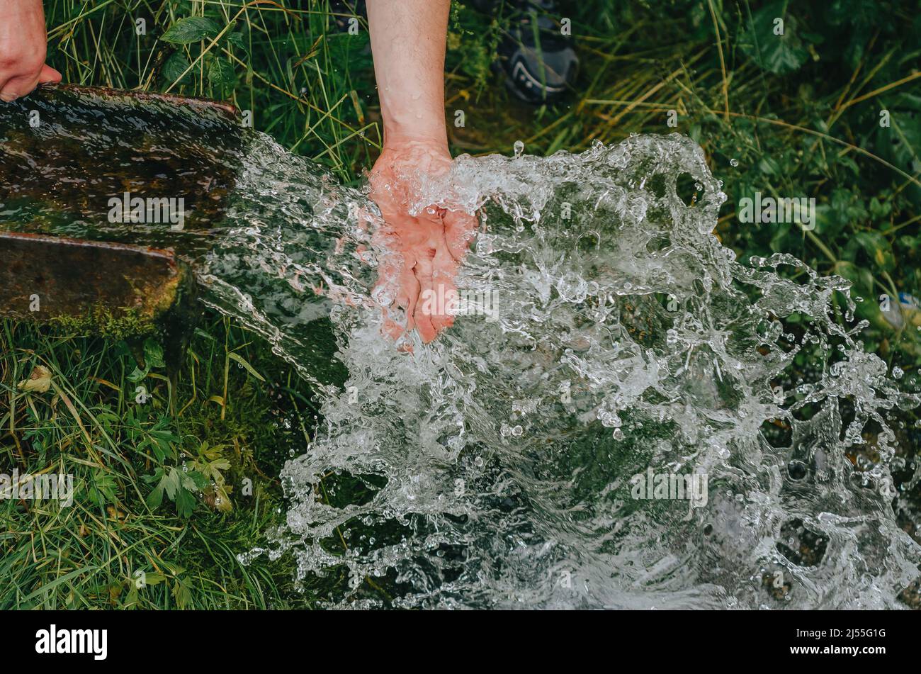 Refreshment with cold clean water on hot summer day. The flow of clean ...