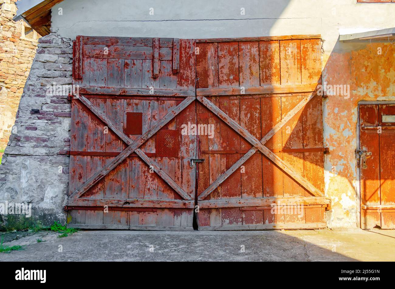 Wooden old big gate in abandoned building. Iron latch. Ancient ...