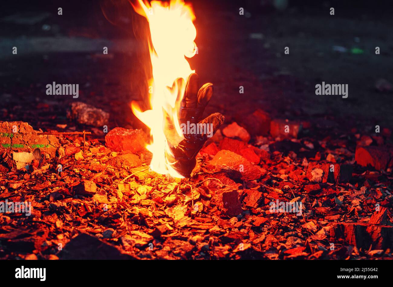 Red flame of raging fire comes from mitten lying on stone Stock Photo ...