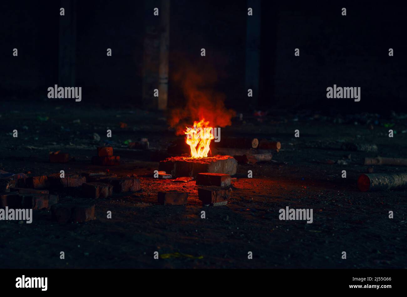 Lighting a fire on stone at night. Small red fire, smoke from flames ...