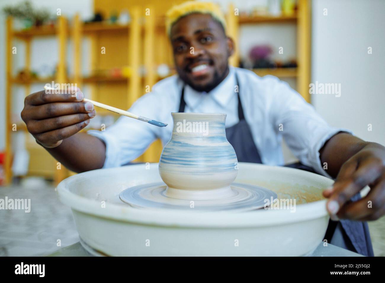 Portrait of positive latin hispanic brazilian man making ceramic pot on ...