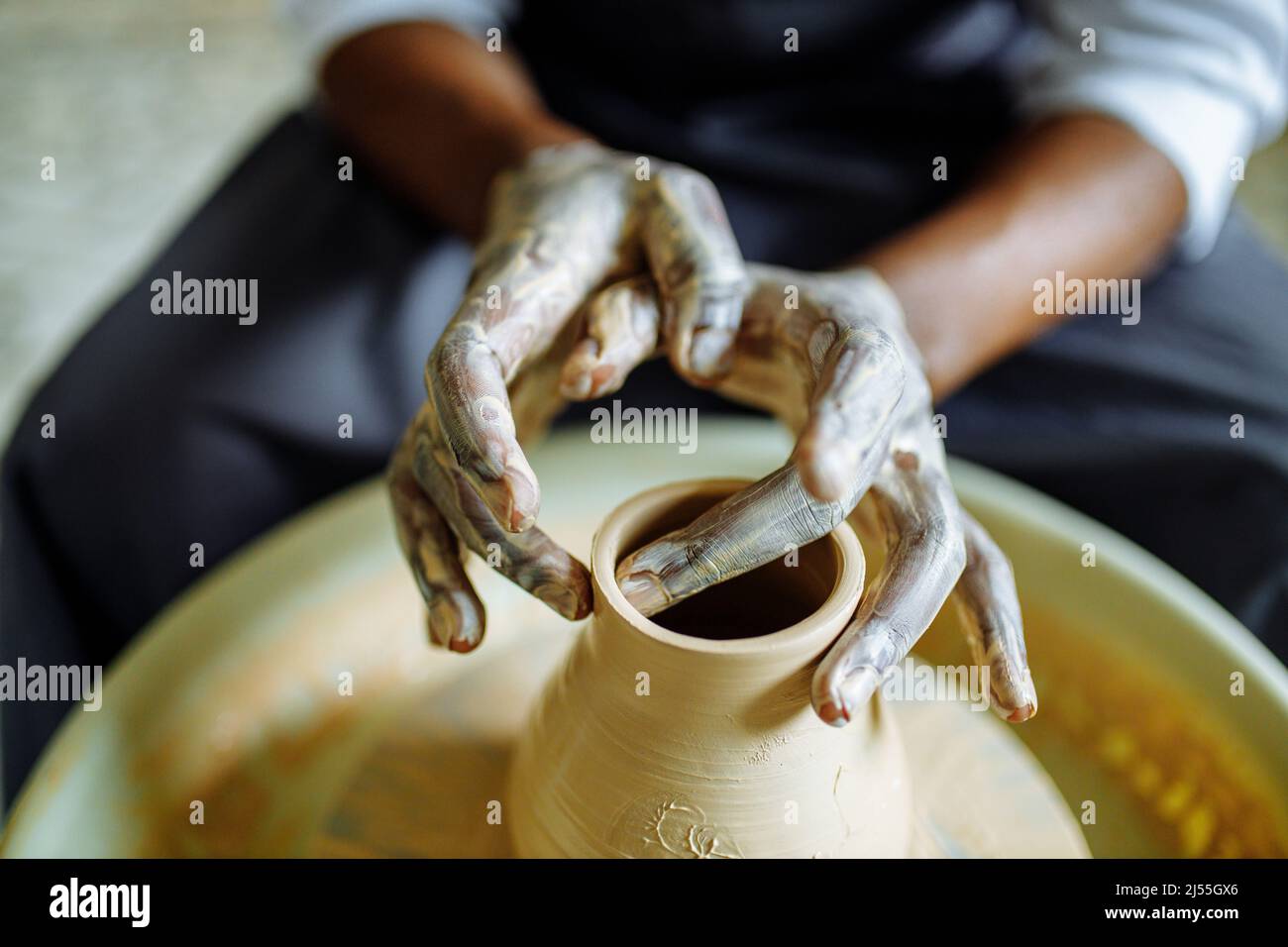 Portrait of positive latin hispanic brazilian man making ceramic pot on ...