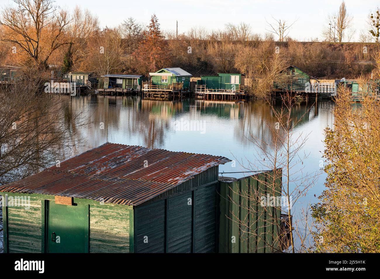 Fisherman's huts on the banks of a river and a pond Stock Photo - Alamy