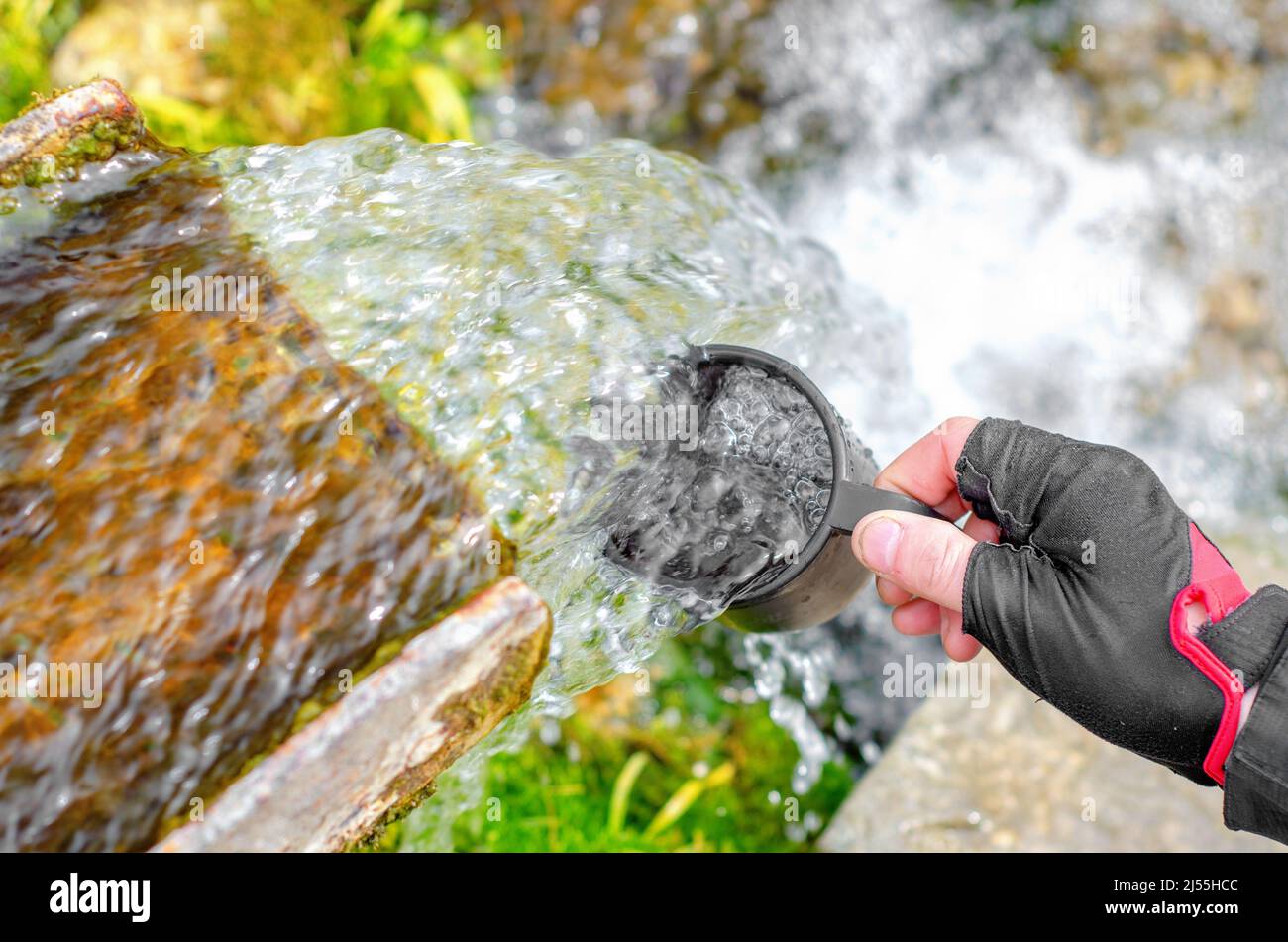 Refreshment with cold clean water on hot summer day. The flow of clean ...