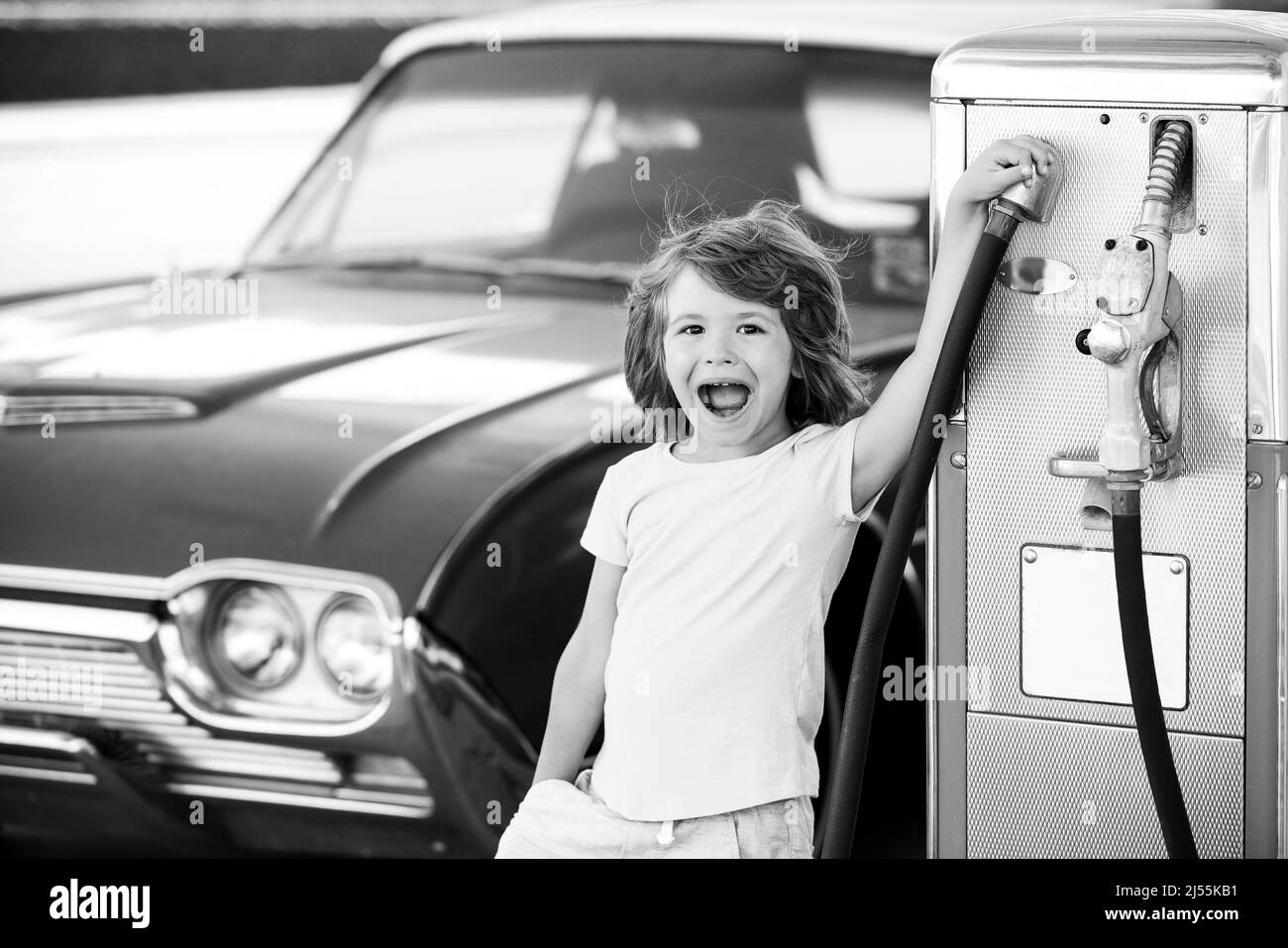 Kid fueling retro car at gas station. Refuel fill up with petrol ...