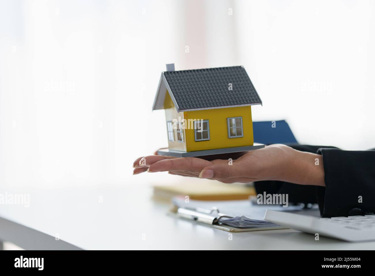 A woman holding and checking house model .Real Estate House Appraisal ...