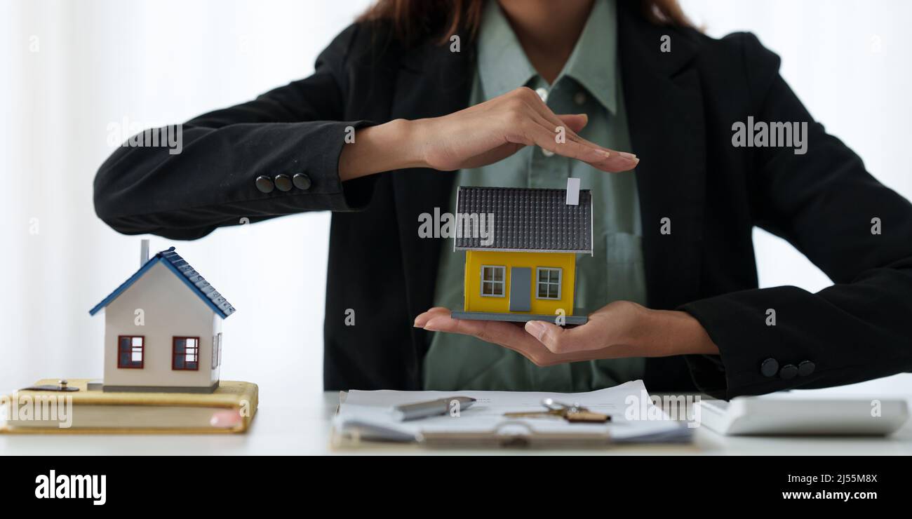 A woman holding and checking house model .Real Estate House Appraisal ...