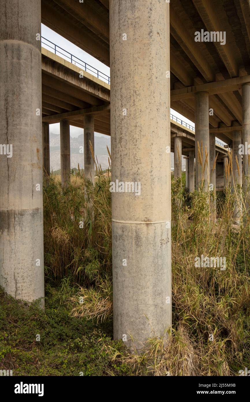 Semi-abstract architectural detail of road bridge columns surrounded by ...