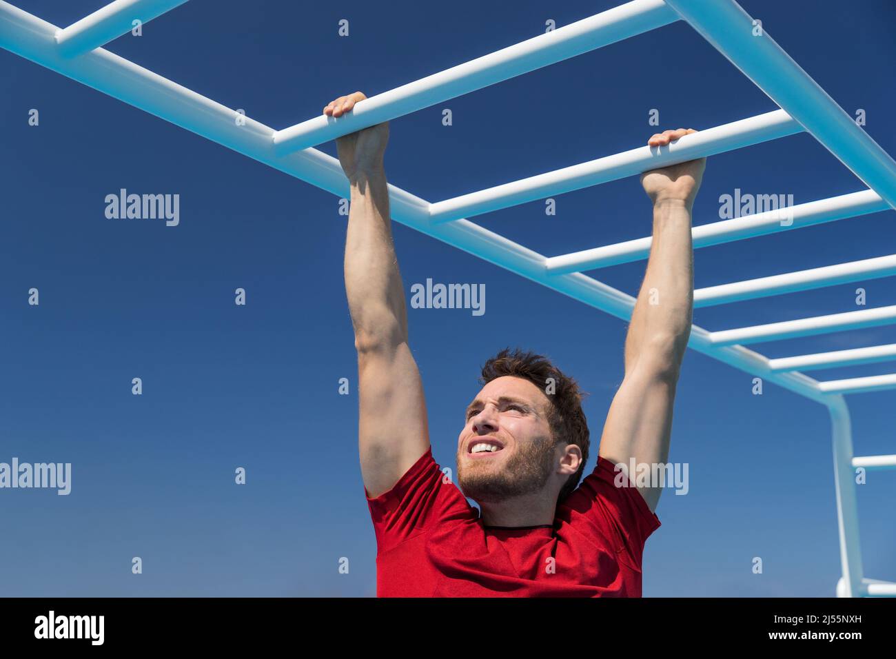 Fitness monkey bars man training arms muscles on jungle gym outdoors in ...