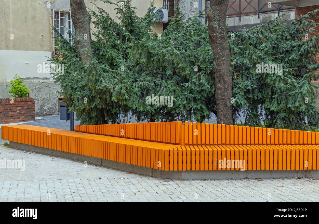 Long Orange Bench Seat in City Park Stock Photo - Alamy