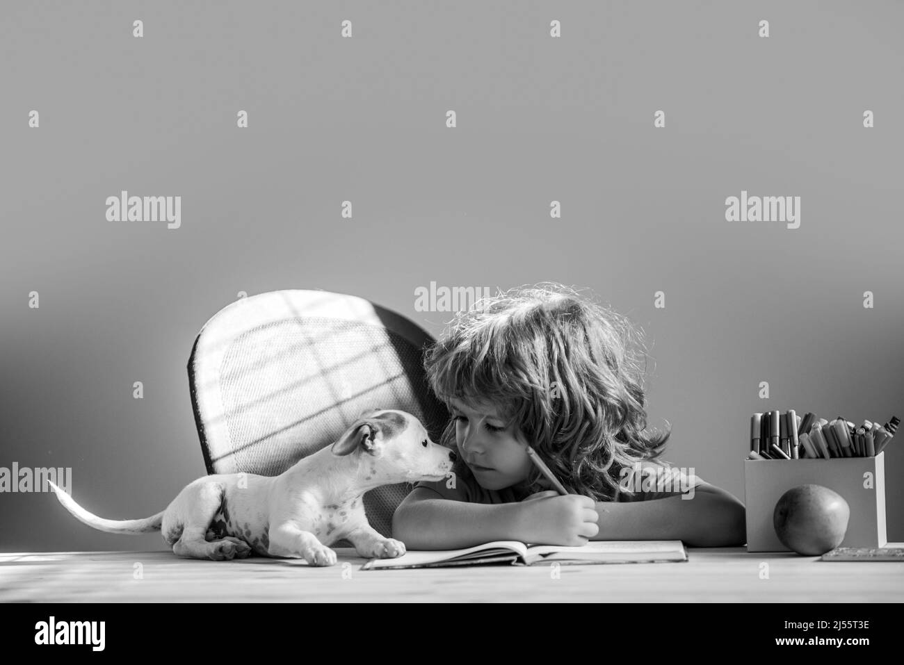 Cute child learning at home. Puppy dog helping kid with education ...