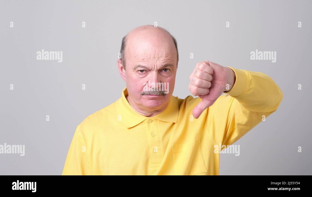 sulking mature caucasian man showing his dislike and disappointment ...