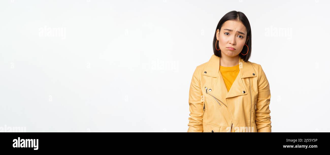 Portrait of sad korean woman sulking, frowning and looking upset ...