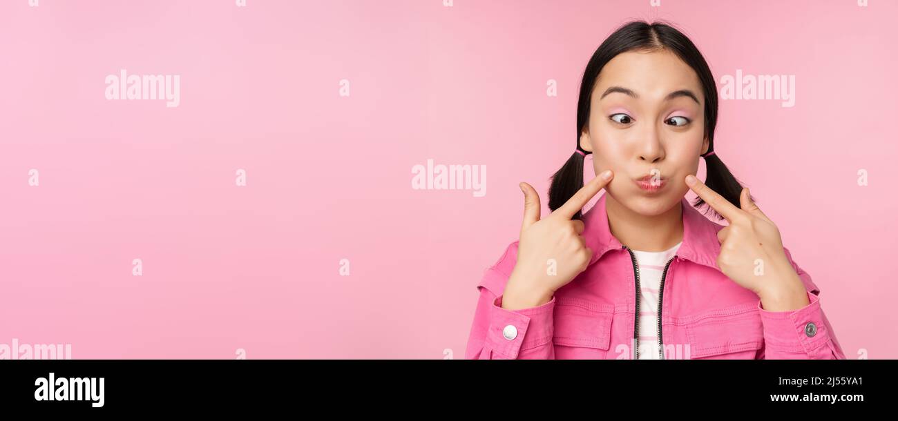 Close up portrait of young asian girl showing her dimples, poking ...