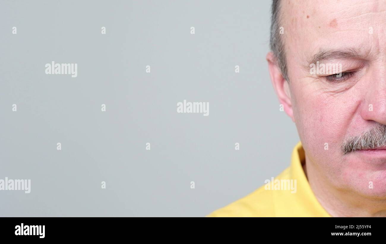 Elderly man half face closeup with copyspace. Sad negative human ...