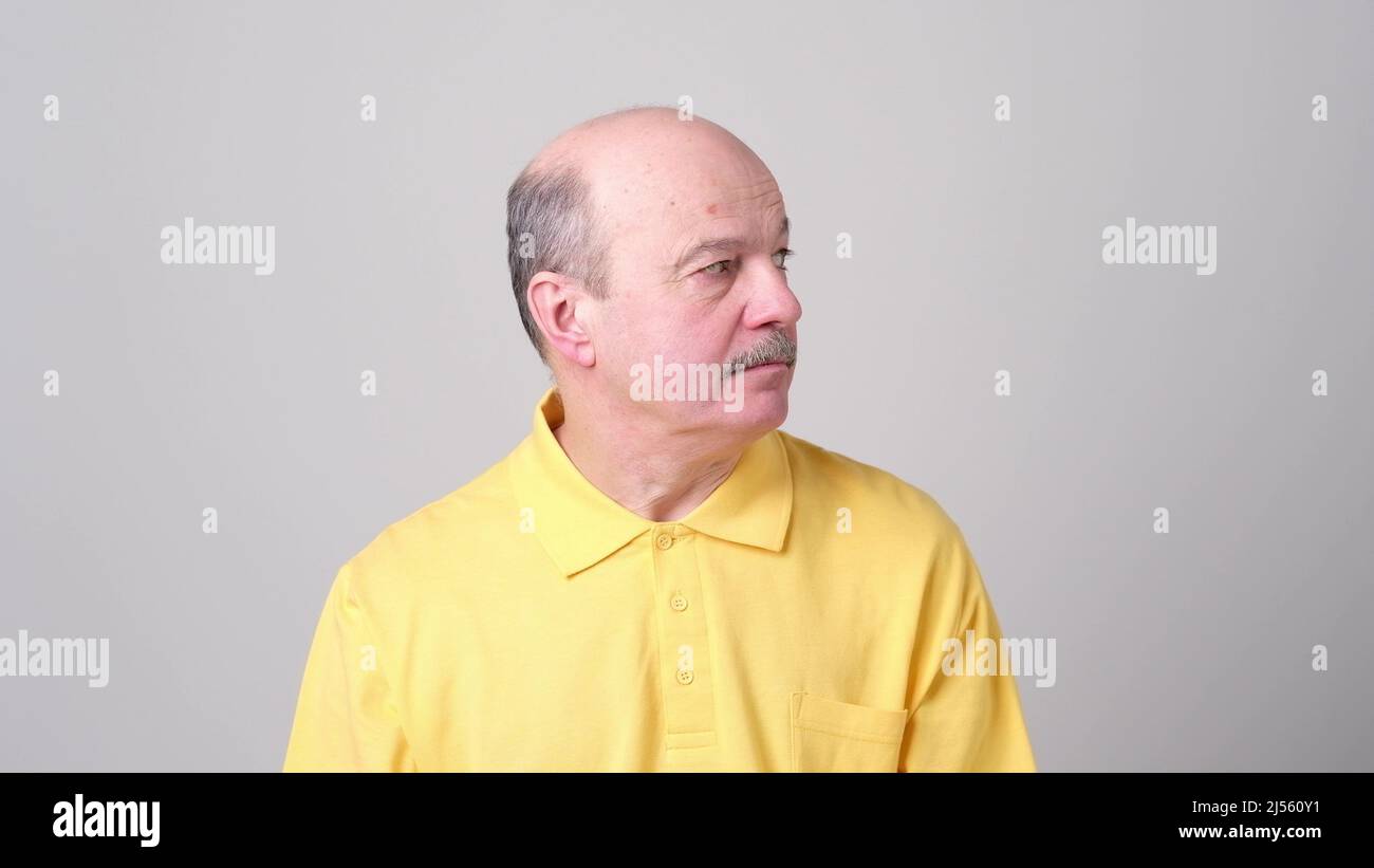 Senior man looking aroung as he is lost and does not know where he is ...