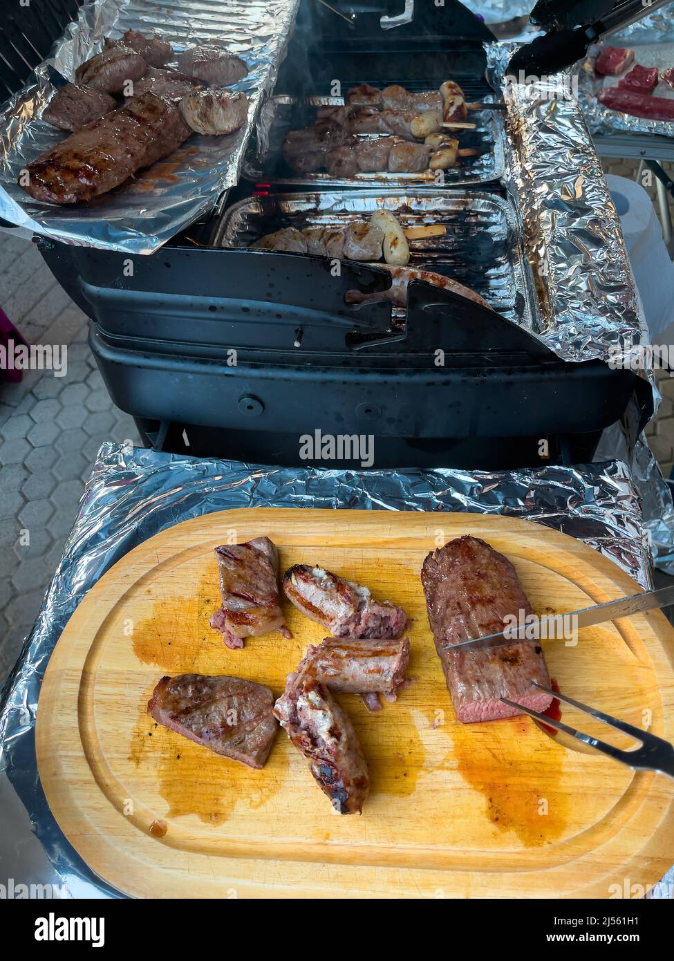 Preparing grilled meat for a homemade barbecue party Stock Photo - Alamy
