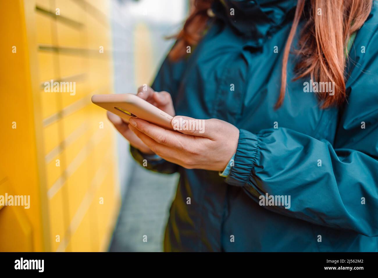 Woman picks up mail from automated self-service post terminal machine ...