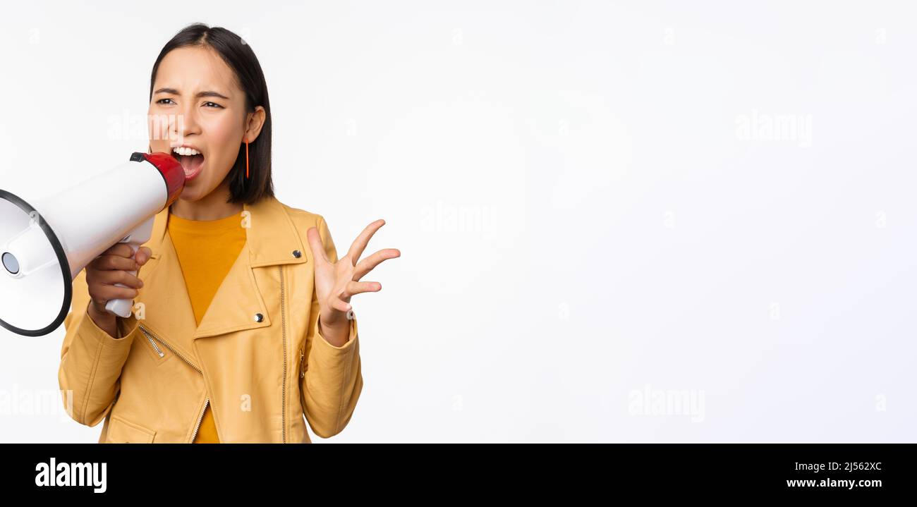 Portrait of young asian woman protester, screaming in megaphone and ...