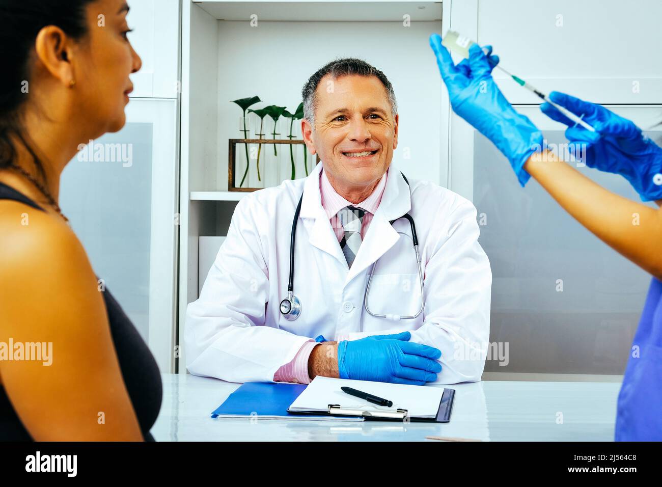 nurse practitioner preparing injection to a female patient in hospital ...
