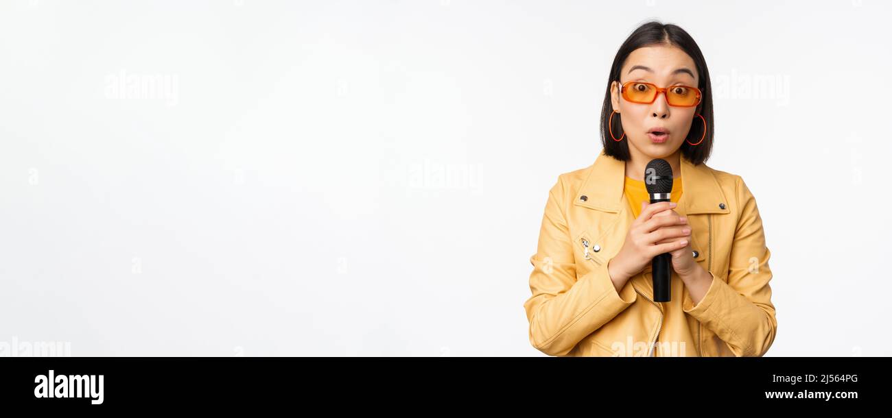 Portrait of beautiful asian woman in sunglasses, stylish girl singing ...