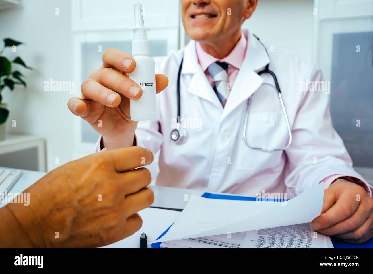 smiling doctor physician and nurse practitioner giving nasal spray to ...